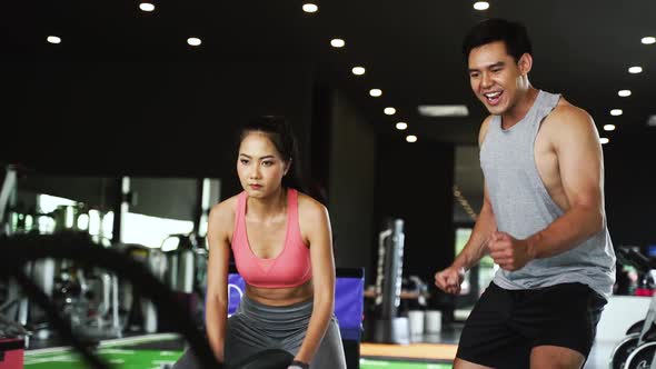Asian Personal Trainer Coaching a Bodybuilding Woman to Perform Battle ...