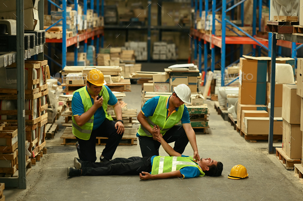 Two industrial worker are helping and giving the injured first aid to ...
