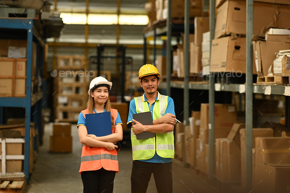 Male and female workers wearing hardhats and reflective jacket standing ...