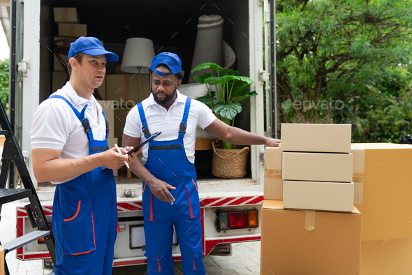Man mover worker in blue uniform check lists on clipboard while ...
