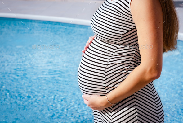 Unrecognizable caucasian pregnant woman stroking baby bump,belly near ...