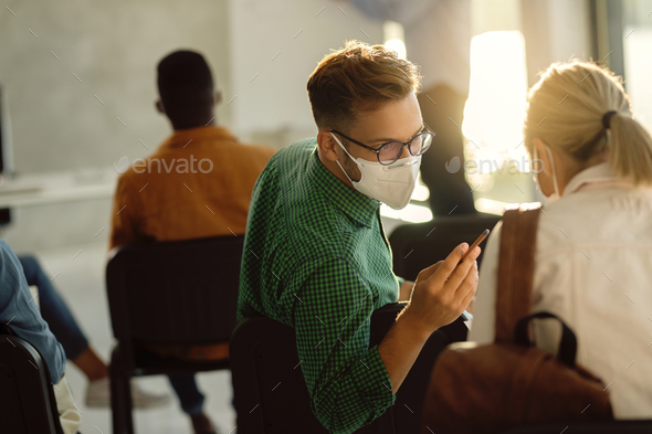 University students with face masks talking during a class in lecture ...