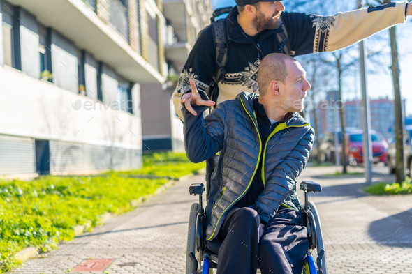 Disabled person in a wheelchair laughing with a friend in a chair on ...