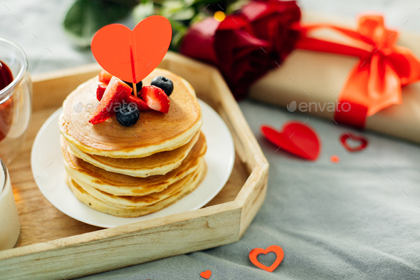 Valentine's day breakfast concept. Pancakes with berries, roses flowers ...