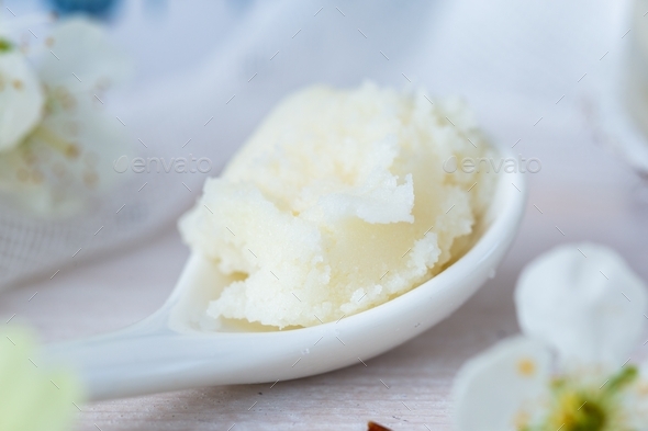 Selective focus shot of a spoonful of shea butter and some white ...