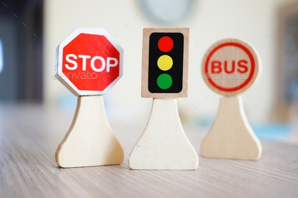 Wooden toy street signs: "Stop", "Bus", "traffic light", placed on the ...