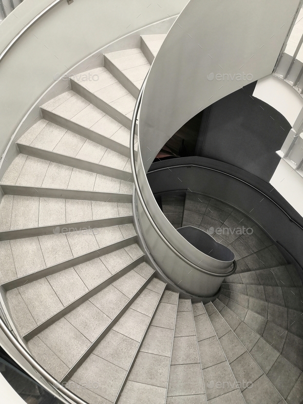 Vertical greyscale shot of round staircase with interesting modern ...