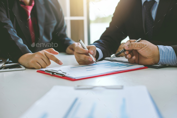 Business people gather to analyze marketing and investment information ...