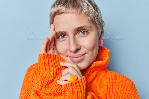 Close up portrait of charming gentle woman touches face smiles and ...