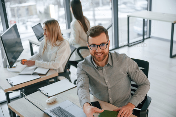 Front view of man. Successful team are working together in the office ...