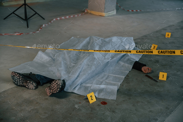 Dead body of a man is on the ground, covered in white cloth. Conception ...