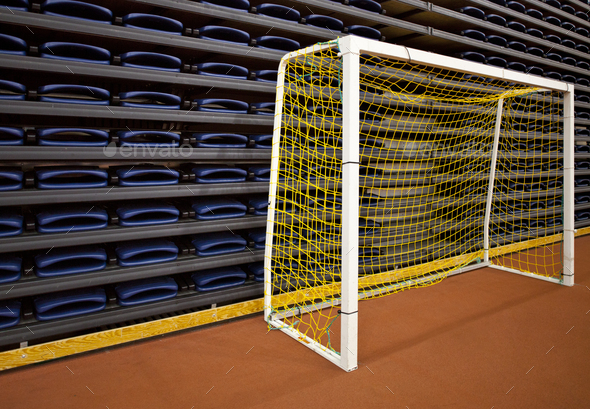 Stack of folded seats at an indoor sports venue, and a practise ...
