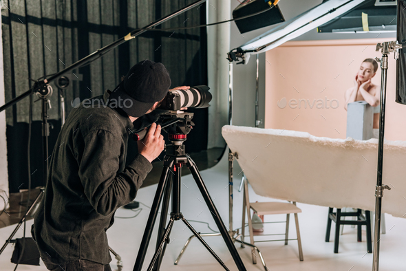 Cameraman filming beautiful woman in photo studio Stock Photo by ...