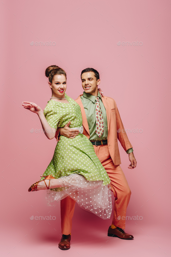 handsome dancer hugging girl while dancing boogie-woogie on pink ...