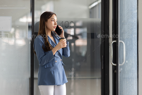 Informal Call Portrait of Happy young Asian woman in office calling her ...