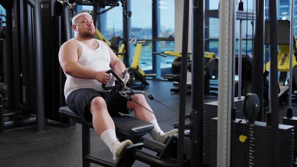 Fat Burning Overweight Funny Man Lifting Blocks on Rowing Machine ...