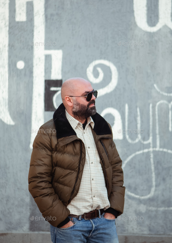 brutal bald bearded middle-aged man in cold weather Stock Photo by loskyt7