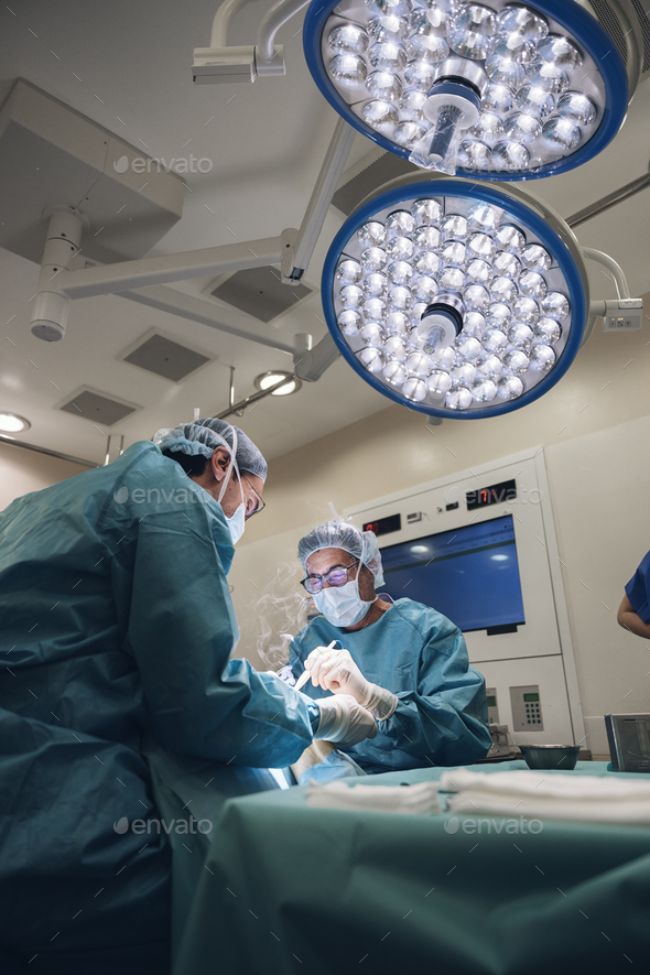 Operation room with medical staff during surgery Stock Photo by nunezimage