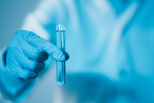 Scientist hand hold test tubes filled with blue sample chemicals in ...
