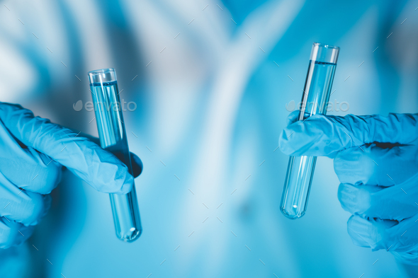 Scientist hand hold test tubes filled with blue sample chemicals in ...
