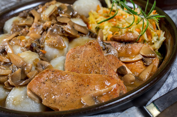 Stewed pork chop in a bright mushroom sauce. Stock Photo by foto_pstryki