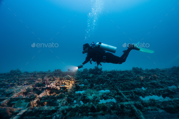 Diving instructor showing the difference in colors underwater. deep ...