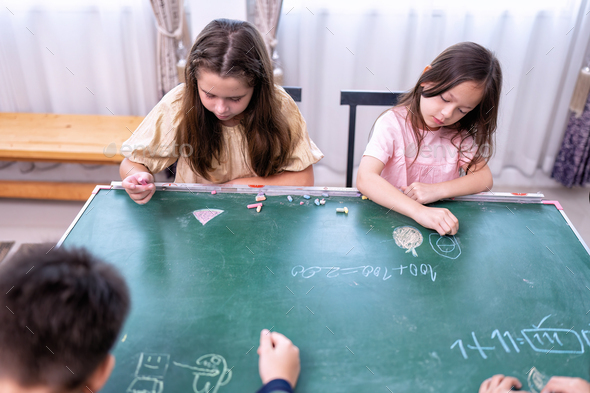 Children in class room happy laughing enjoy draw picture on green board ...