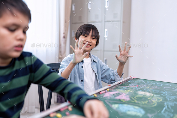 Children in class room happy laughing enjoy draw picture on green board ...