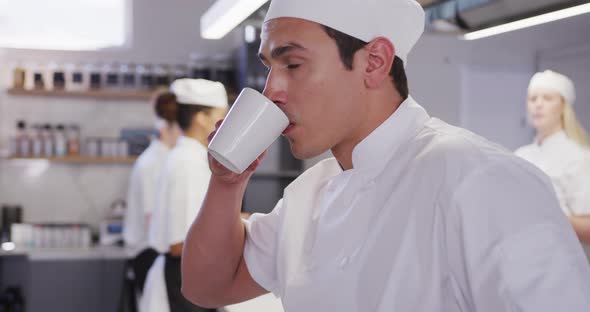 Mixed race male chef wearing chefs whites in a restaurant kitchen ...