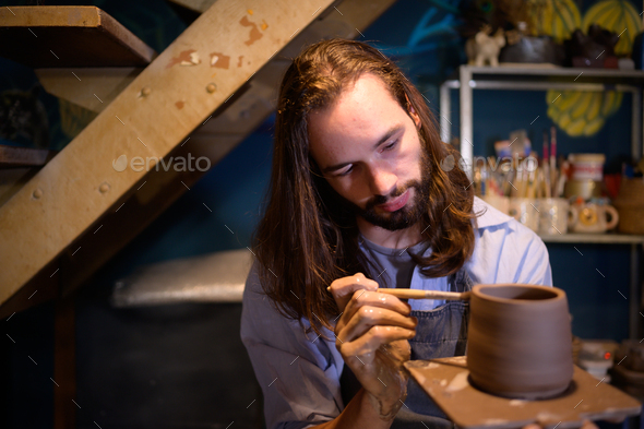 Pottery artist, Young making a piece of clay molding calmly Stock Photo ...