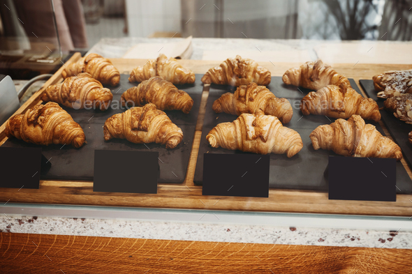 Bistro showcase with shelves of freshly croissants and bread in ...