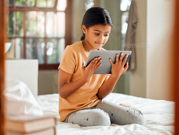 Little girl, tablet and smile on bed for entertainment, education or ...