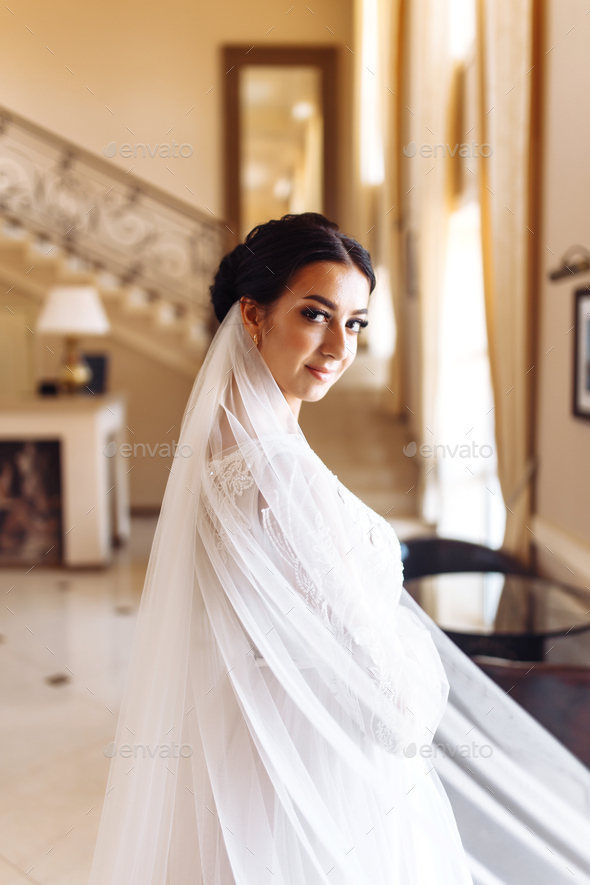 Beautiful bride in fashion wedding dress with a long luxury veil ...