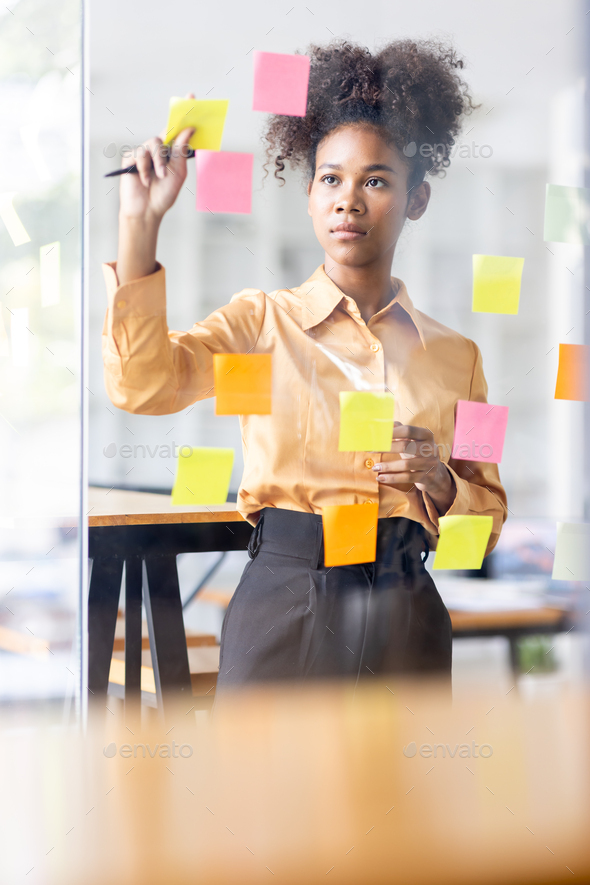 Young Serious african american Creative team use post it notes to share ...