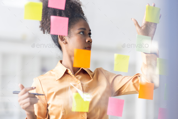 Young Serious african american Creative team use post it notes to share ...