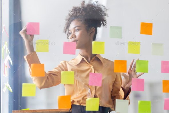 Young Serious african american Creative team use post it notes to share ...