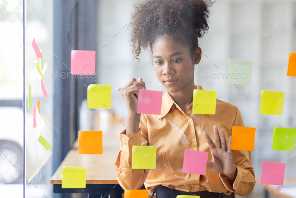Young Serious african american Creative team use post it notes to share ...