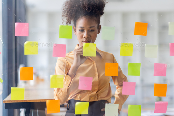 Young Serious african american Creative team use post it notes to share ...