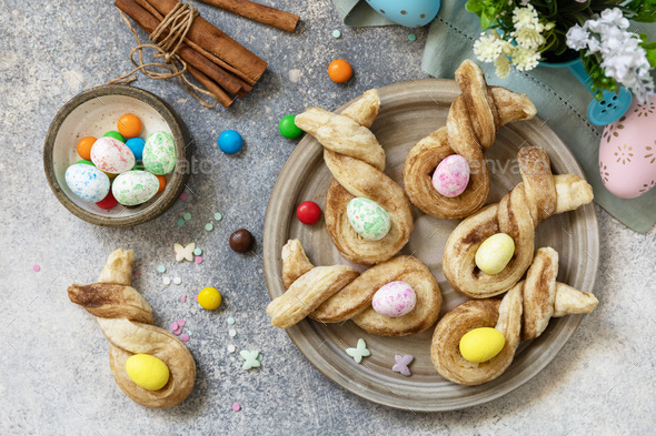 Easter rabbit-shaped buns puff pastry with cinnamon on a stone tabletop ...