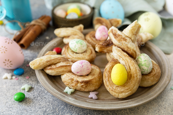 Easter rabbit-shaped buns puff pastry with cinnamon on a stone tabletop ...