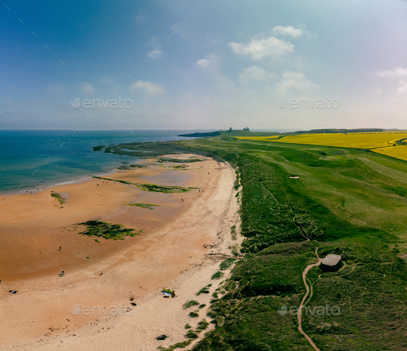 Embleton Bay and Burn sandy beach with the ruins of Dunstanburgh Castle ...