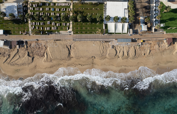 Aerial view of ocean waves breaking on a sandy beach. Beach erosion ...