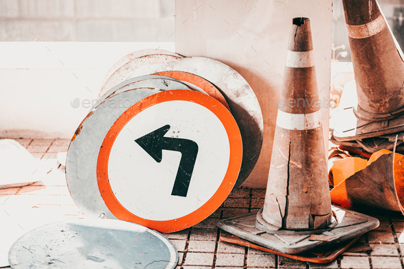 old unused dirty broken road traffic sign banner and traffic cone waste ...
