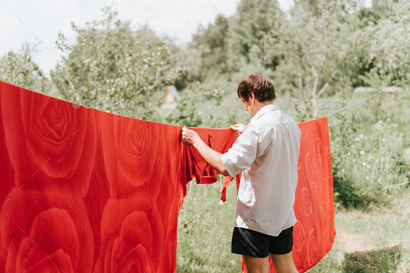 candid young mature choring man chore homework and hanging the laundry ...