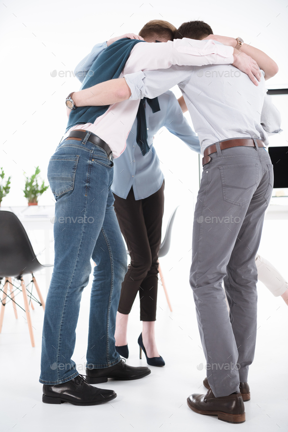 Young businesspeople hugging in modern office, teamwork concept Stock ...