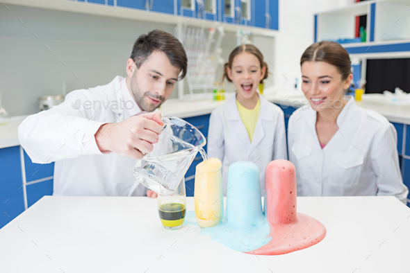 portrait of cheerful teachers and girl student scientists making ...