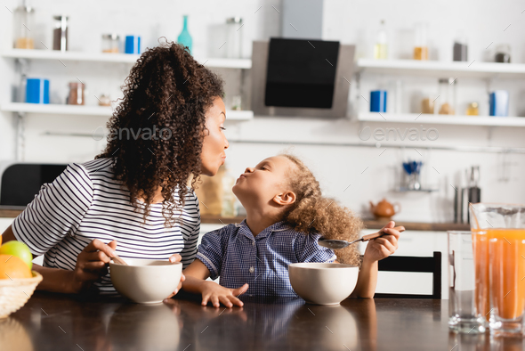 african american mother and daughter making duck faces while looking at ...