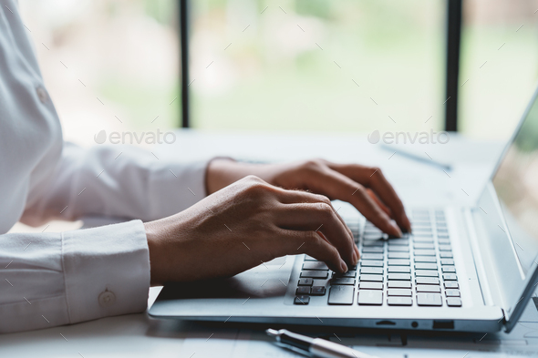 Woman hand who are actively typing and concentrate on work using laptop ...