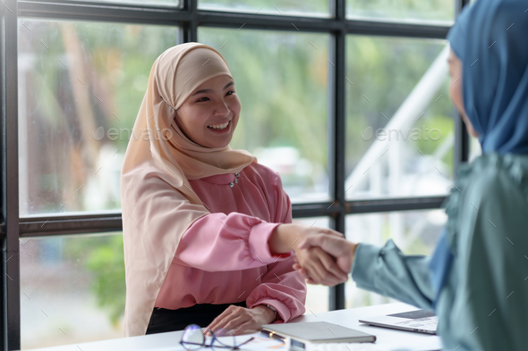 Beautiful Muslim Asian business woman shaking hands to promise to work ...