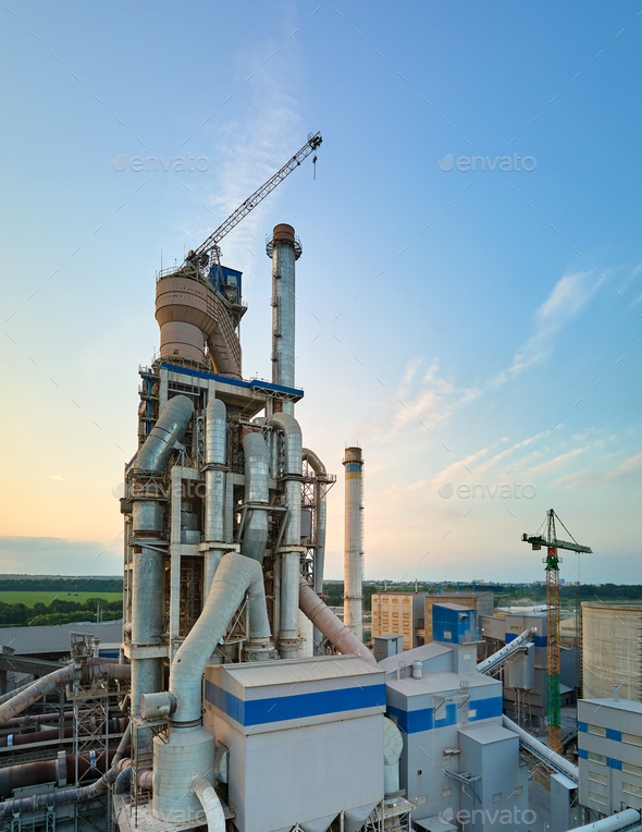 Cement plant with high factory structure and tower cranes at industrial ...